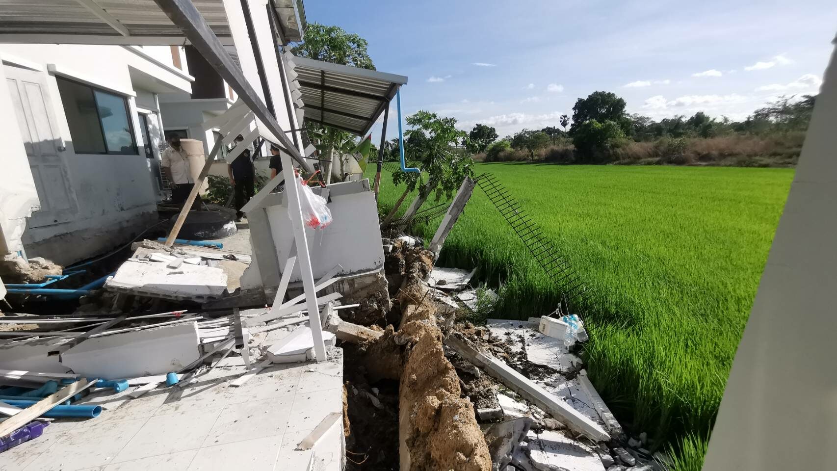 The wall of the housing estate collapsed into the village's fields ...